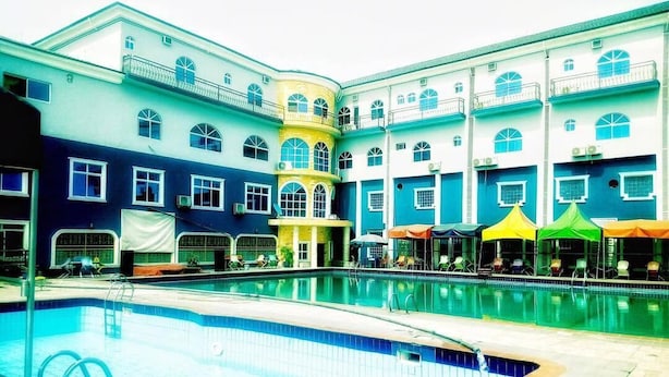 Uma área de piscina com um edifício alto ao fundo.