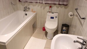Casa de banho com banheira, sanita e lavatório.