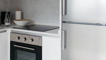 Uma cozinha moderna com eletrodomésticos de aço inoxidável, incluindo micro-ondas, forno e geladeira.