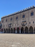 Um edifício histórico com uma série de janelas em arco e uma cornija crenelada.