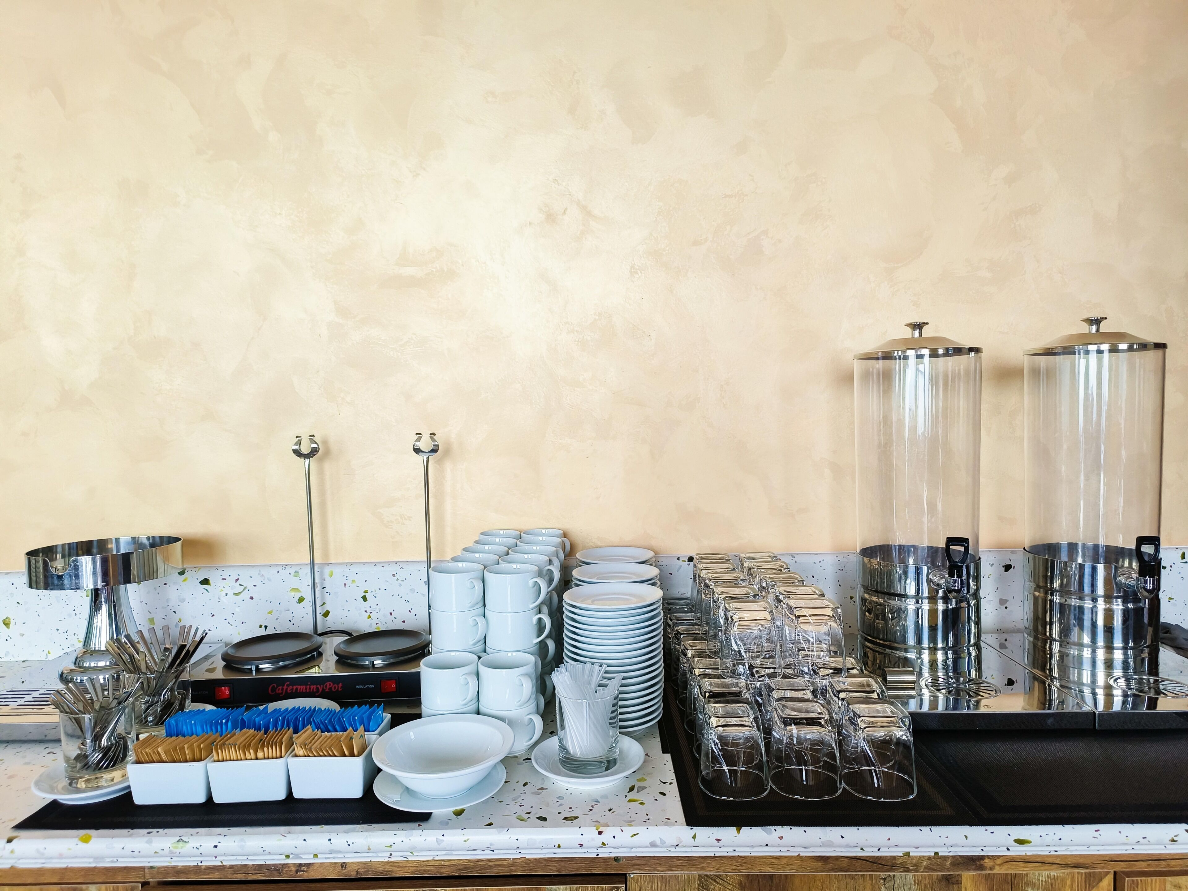 Uma mesa de buffet com diversos pratos, utensílios e recipientes.
