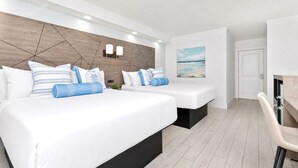 Quarto de hotel com duas camas, uma escrivaninha, uma cadeira, um quadro na parede e cabeceira de madeira.