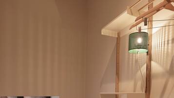 Um interior moderno com escada, cama, escrivaninha e luminária suspensa.
