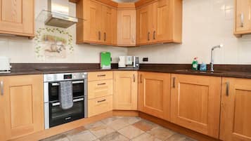 Um frigorífico, uma máquina de lavar louça, utensílios de cozinha