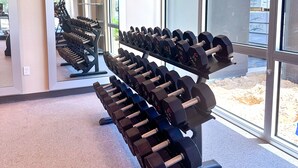 Uma academia com fileiras de halteres e equipamentos de ginástica.