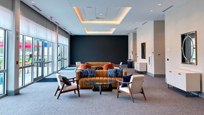 Um hall amplo com um conjunto de sofás moderno, uma mesa de centro e um espaço de estar com cadeiras.