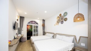 Quarto de hotel moderno com duas camas, uma mesa de trabalho e uma janela grande.
