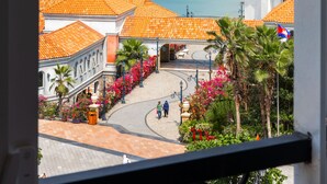 Vista costeira com marina, edifícios com telhados de laranja e um caminho para pedestres.
