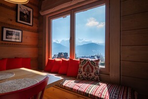 Uma cabana de madeira com uma janela grande de frente para as montanhas.