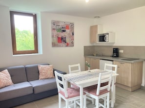 Apartamento conforto, 1 cama Queen e sofá-cama, vista para o jardim | Área de estar | TV de tela plana 32 polegadas com canais digitais, TV