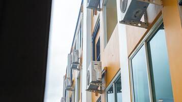 Fachada de edifício com vários aparelhos de ar condicionado fixados na parede externa.