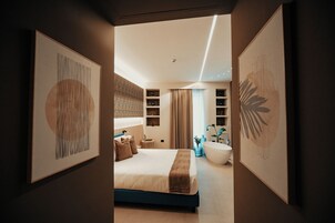 Quarto moderno com cama grande, banheira integrada e design minimalista.