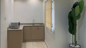 Uma cozinha moderna com forno embutido, pia e janela com persianas.