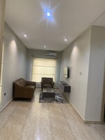 Uma sala de estar moderna com sofá, poltrona e mesa de centro.