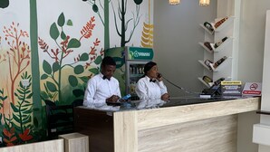 Uma receção com design moderno, uma máquina de café e um mural na parede.