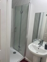 Chuveiro, secador de cabelo, toalhas de banho, sabonete