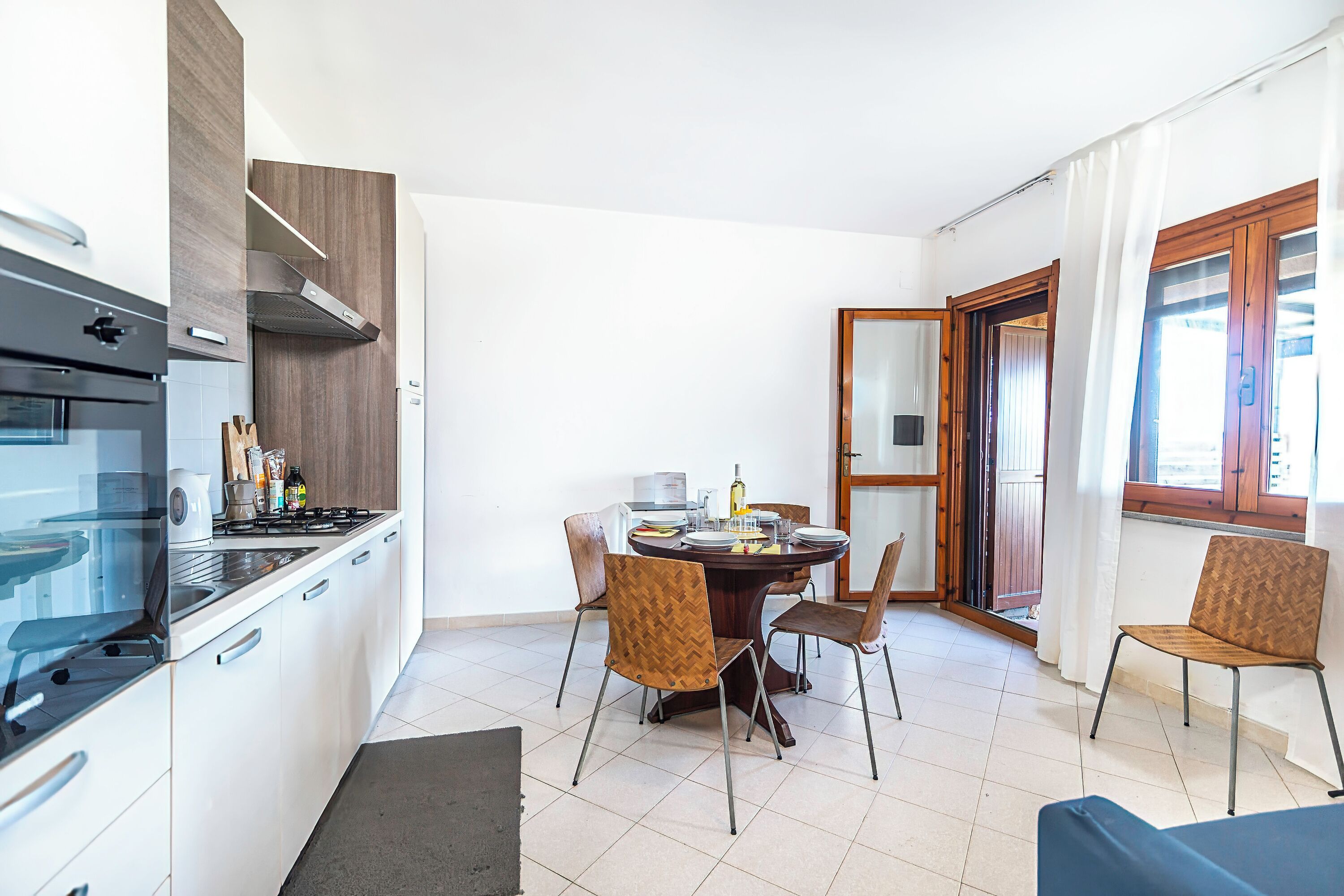 Um frigorífico, um forno, uma placa de cozinha, uma cafeteira/bule 