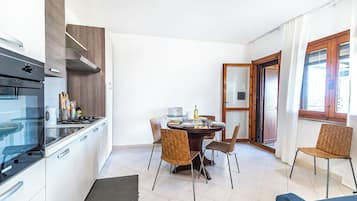 Um frigorífico, um forno, uma placa de cozinha, uma cafeteira/bule