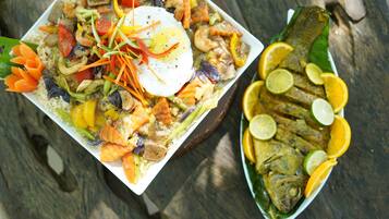 Uma refeição com diversos vegetais, peixe e um ovo escaldado em um prato.