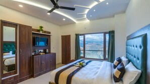 Quarto com cama, televisão, guarda-roupa e varanda com vista.