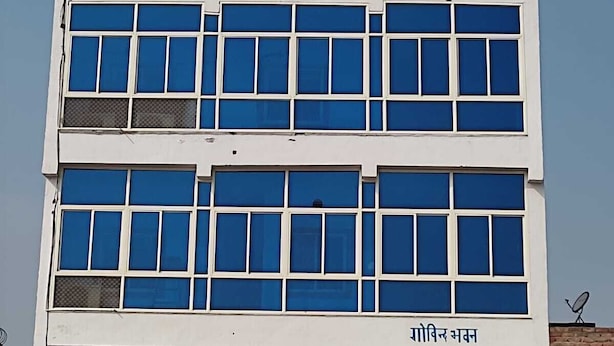 Um edifício de vários andares com uma placa que diz "A.C. ROOMS GOVIND BHAWAN".