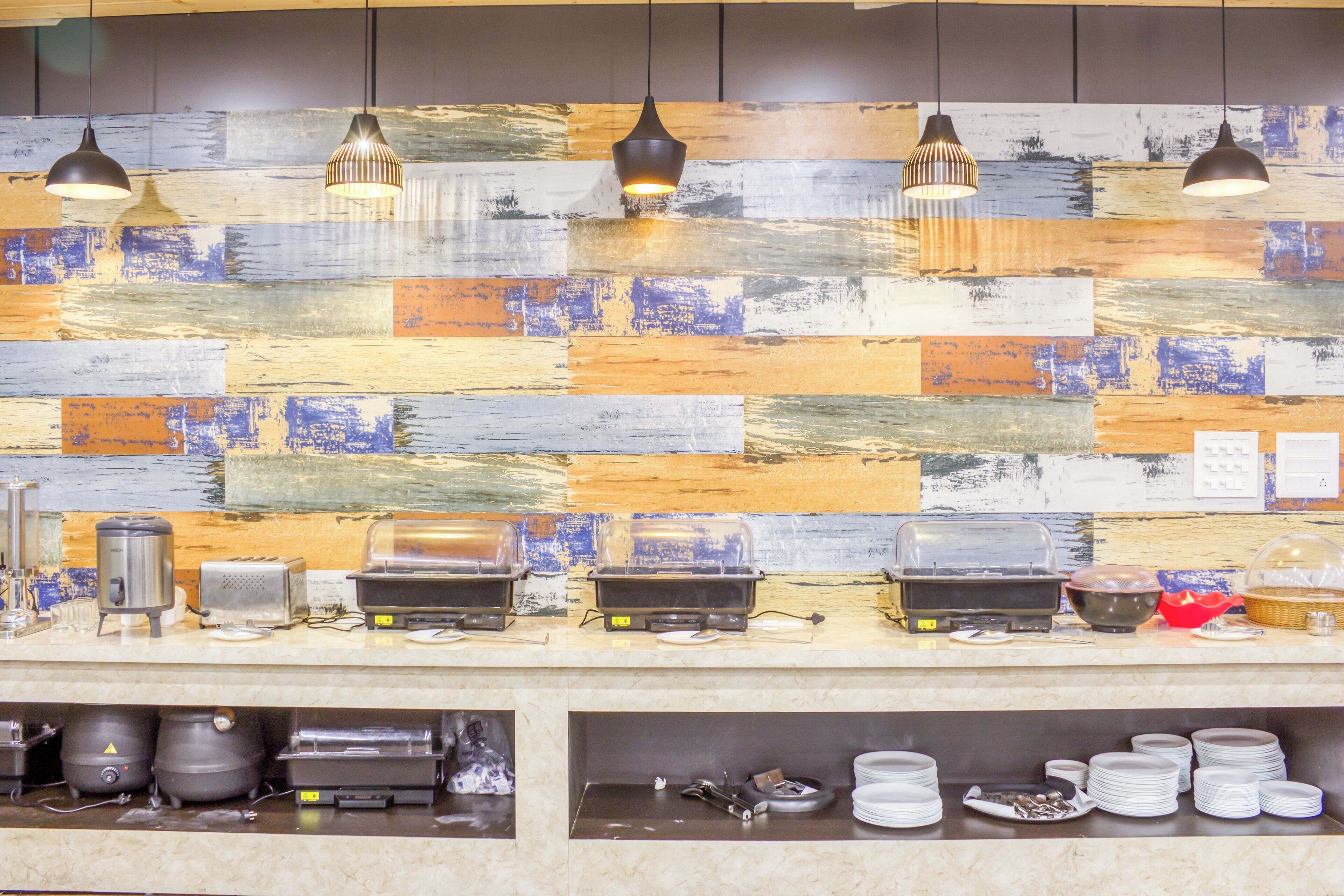 Buffet montado com diversas estações de serviço, incluindo opções de comida quente e fria, e uma variedade de pratos expostos no balcão.