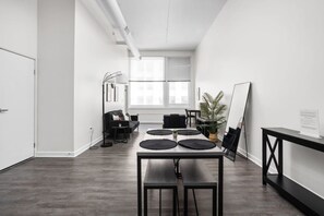 Uma sala de conferências moderna e minimalista com uma mesa comprida, cadeiras pretas e um quadro branco.