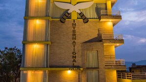 Um hotel com vários andares, varandas e um logo de águia marcante na fachada.