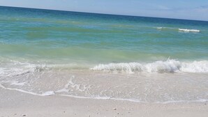 Uma praia com águas turquesa cristalinas e ondas suaves.