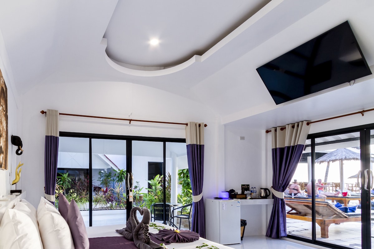 Quarto de hotel moderno com uma grande janela, televisão de tela plana, sofá, mesa de jantar e vista para a área externa.