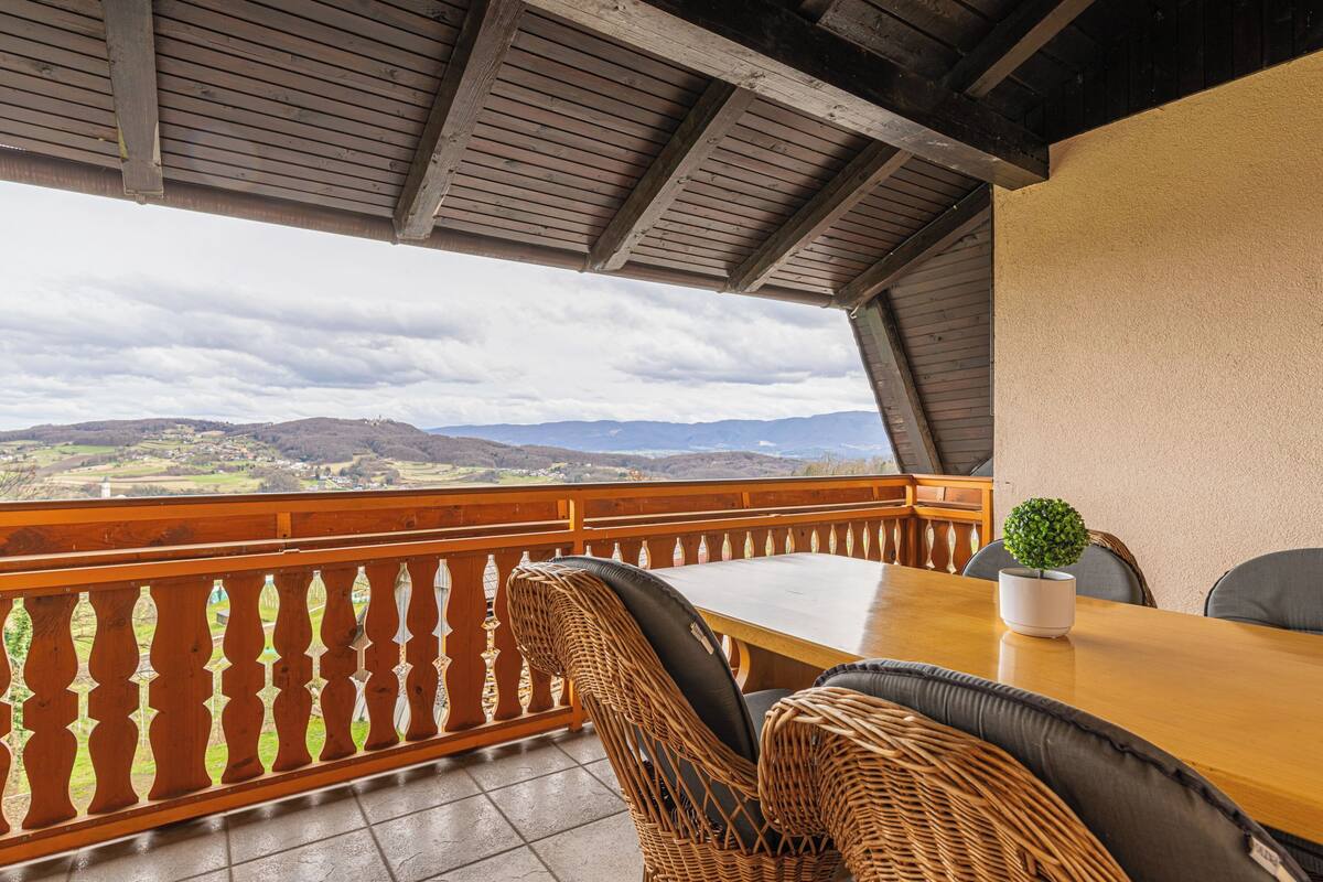 Varanda com mobiliário de vime e vista para o campo.