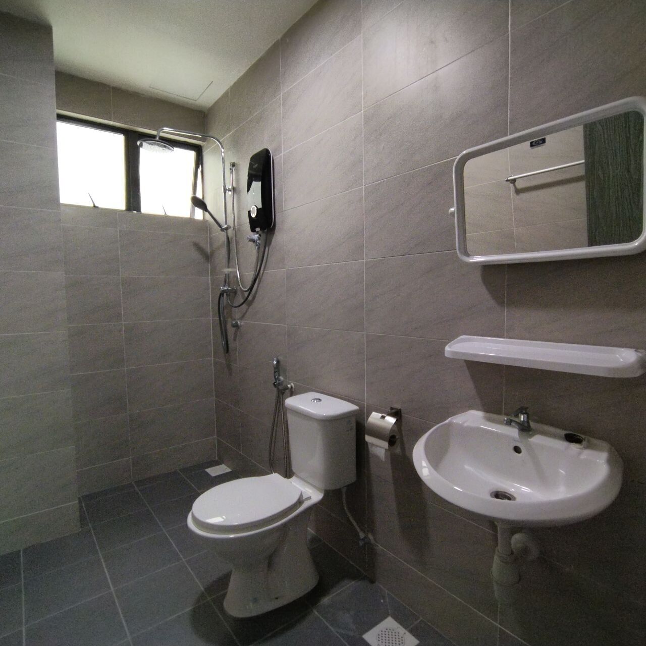 Uma casa de banho moderna com sanita, bidé e lavatório.