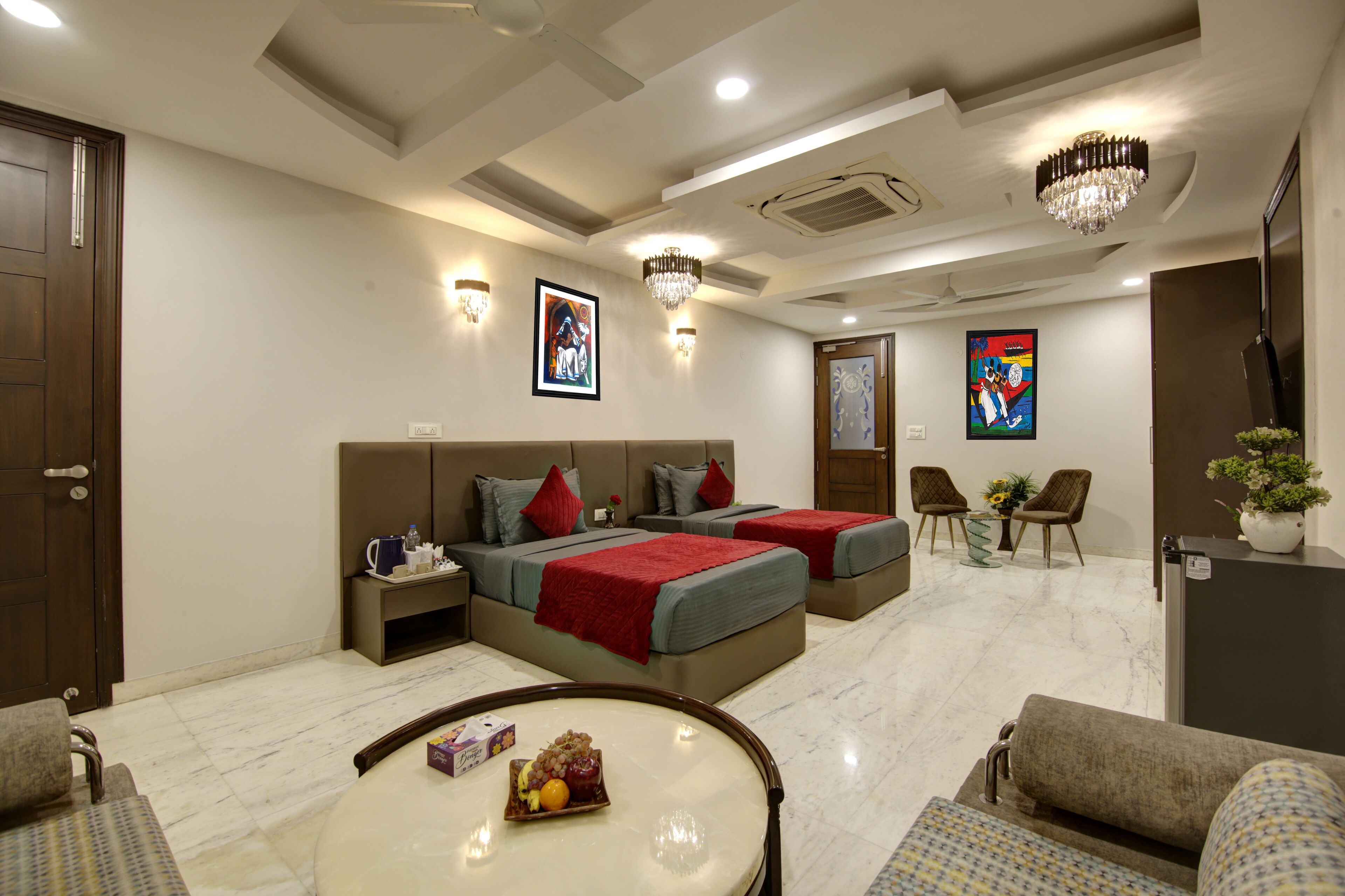 Quarto de hotel com duas camas, área de estar com uma mesa e uma pequena mesa de jantar.