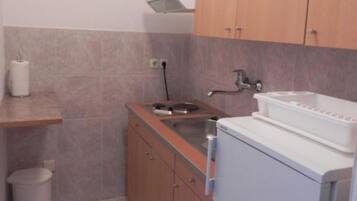 Cozinha compacta com pia, fogão e armários.