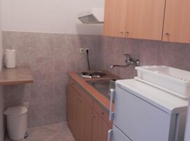 Cozinha compacta com pia, fogão e armários.