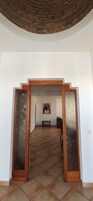 Um corredor com moldura de porta de madeira e piso de azulejos.