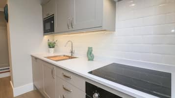 Um frigorífico, uma máquina de lavar louça, utensílios de cozinha