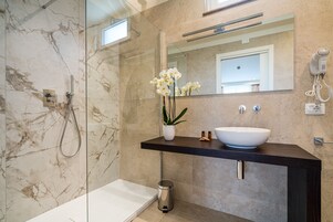 Quarto Deluxe | Casa de banho | Um polibã, um chuveiro fixo, artigos de higiene pessoal grátis 