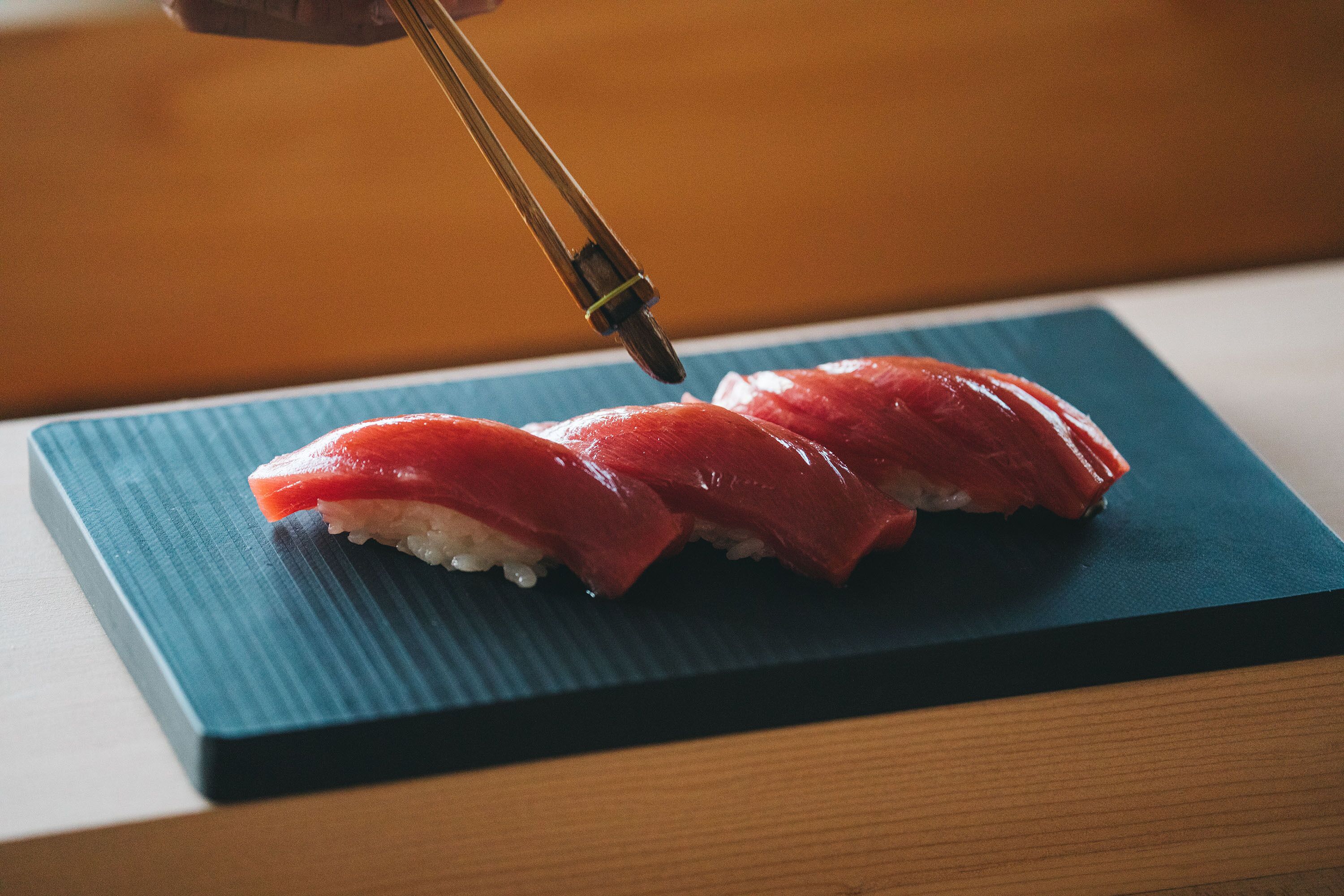 Um prato de sushi sobre um prato azul retangular.