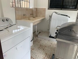 Uma cozinha compacta com fogão branco, pia e geladeira branca.