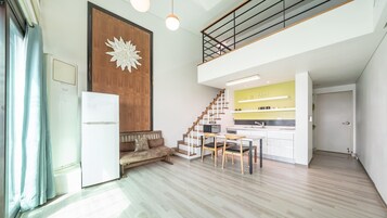 Um apartamento moderno com cozinha, sala de jantar e escada para um andar superior.