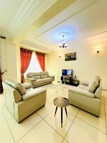 Uma sala de estar com sofá, mesa de centro e televisão.
