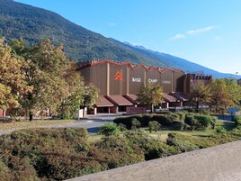 Um edifício grande com uma placa que diz "BASE CAMP LODGE" em frente a um cenário montanhoso.