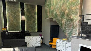 Um interior moderno com uma receção em mármore, área de estar e lareira.