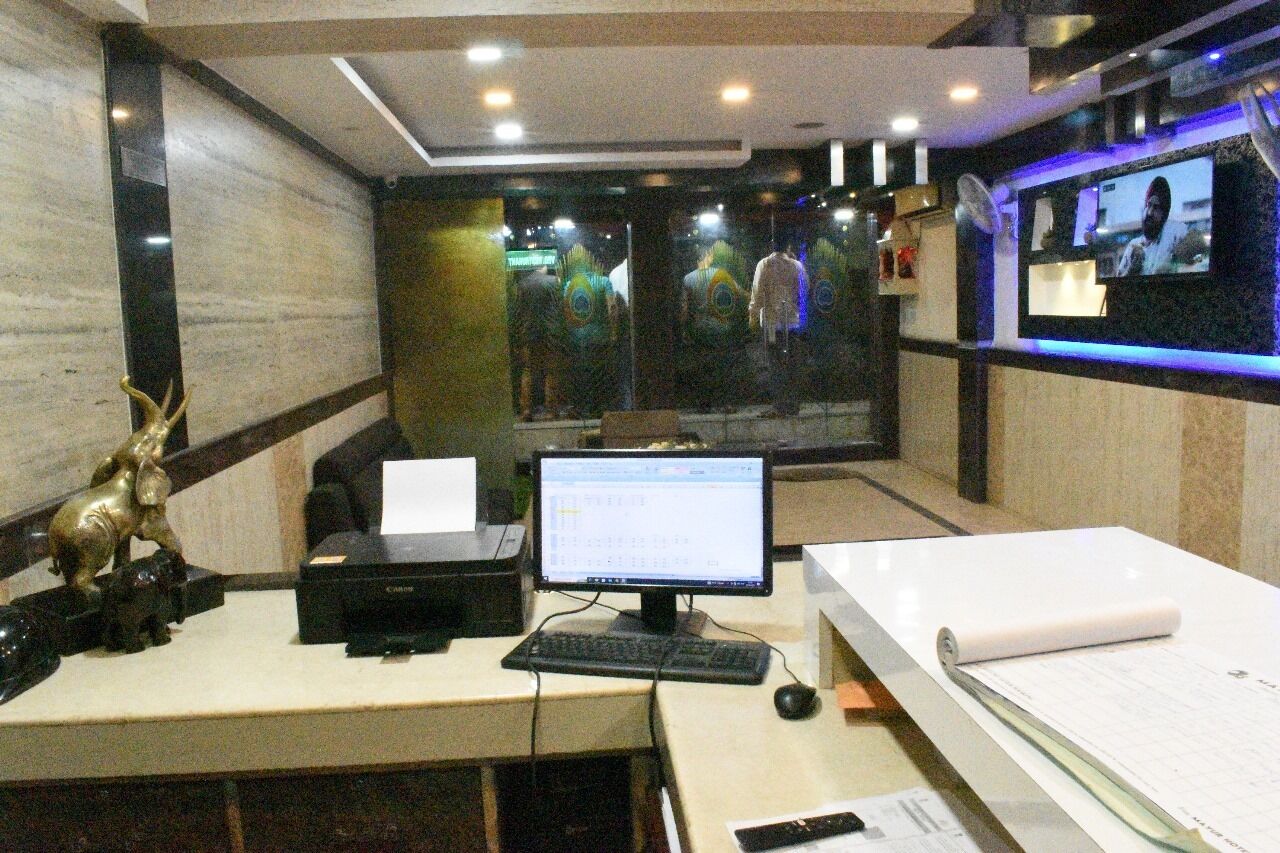 Quarto de hotel com uma mesa, computador e televisão.
