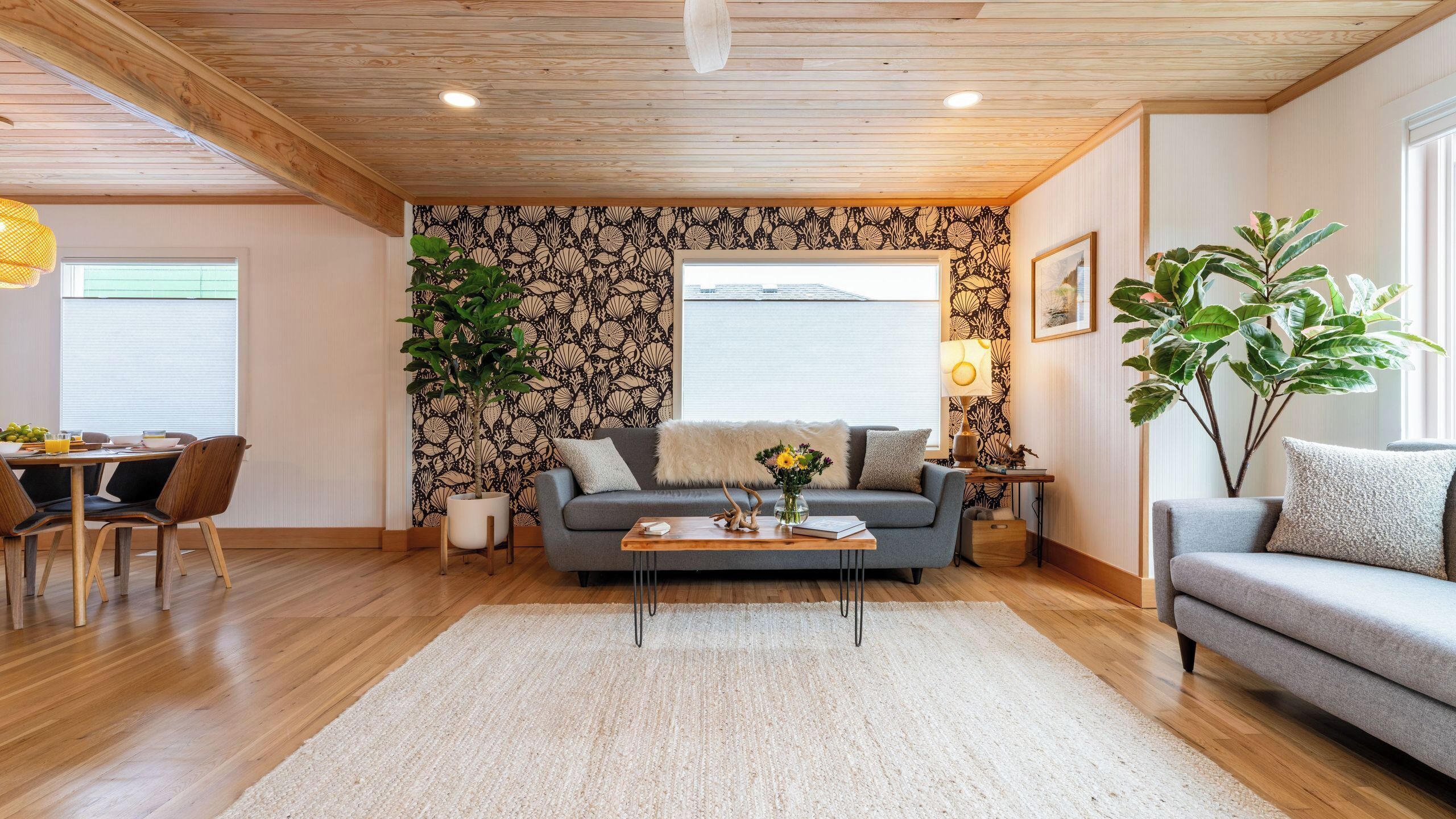 Sala de estar com sofá, mesa de centro e plantas em vasos.