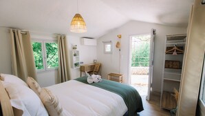 Um quarto com cama, escrivaninha, guarda-roupa e luminária pendente.