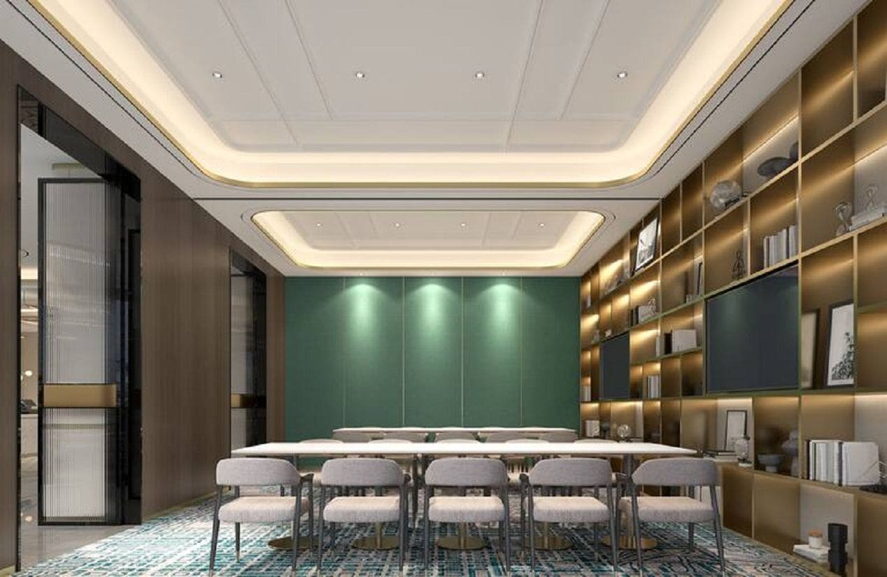 Uma sala de conferências moderna com uma mesa redonda e cadeiras, uma parede de destaque verde e uma estante com quadros.