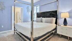 Quarto com cama de dossel, mesa de cabeceira e luminária.