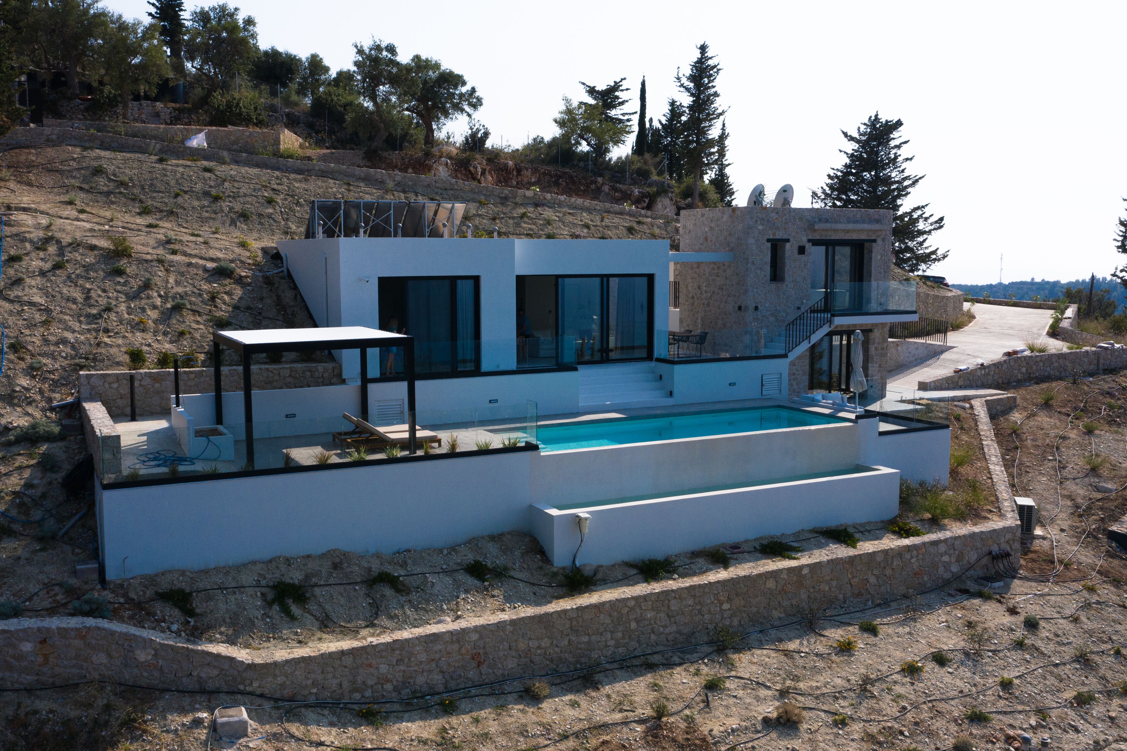 Uma casa moderna com piscina, janelas amplas e fachada de pedra.